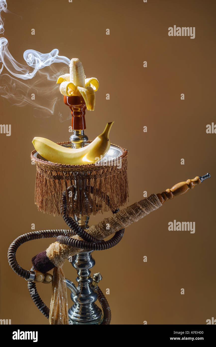 Smoking hookah with fruit head on dark background Stock Photo - Alamy