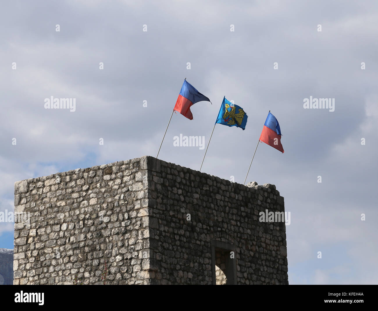 three flags on the ancient tower in Northen Italy. the central flag ...