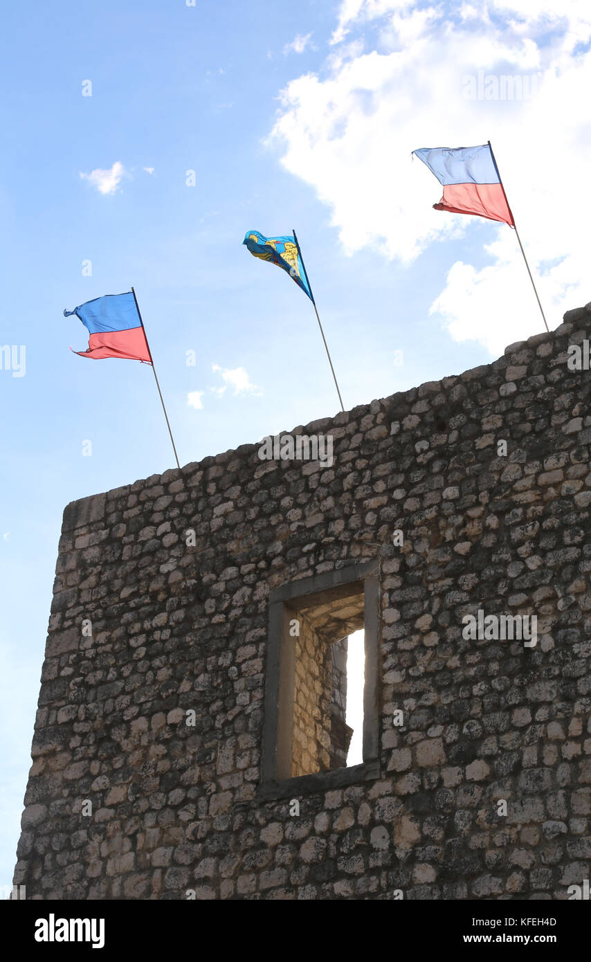 three flags on the ancient tower in the little town of Venzone in ...