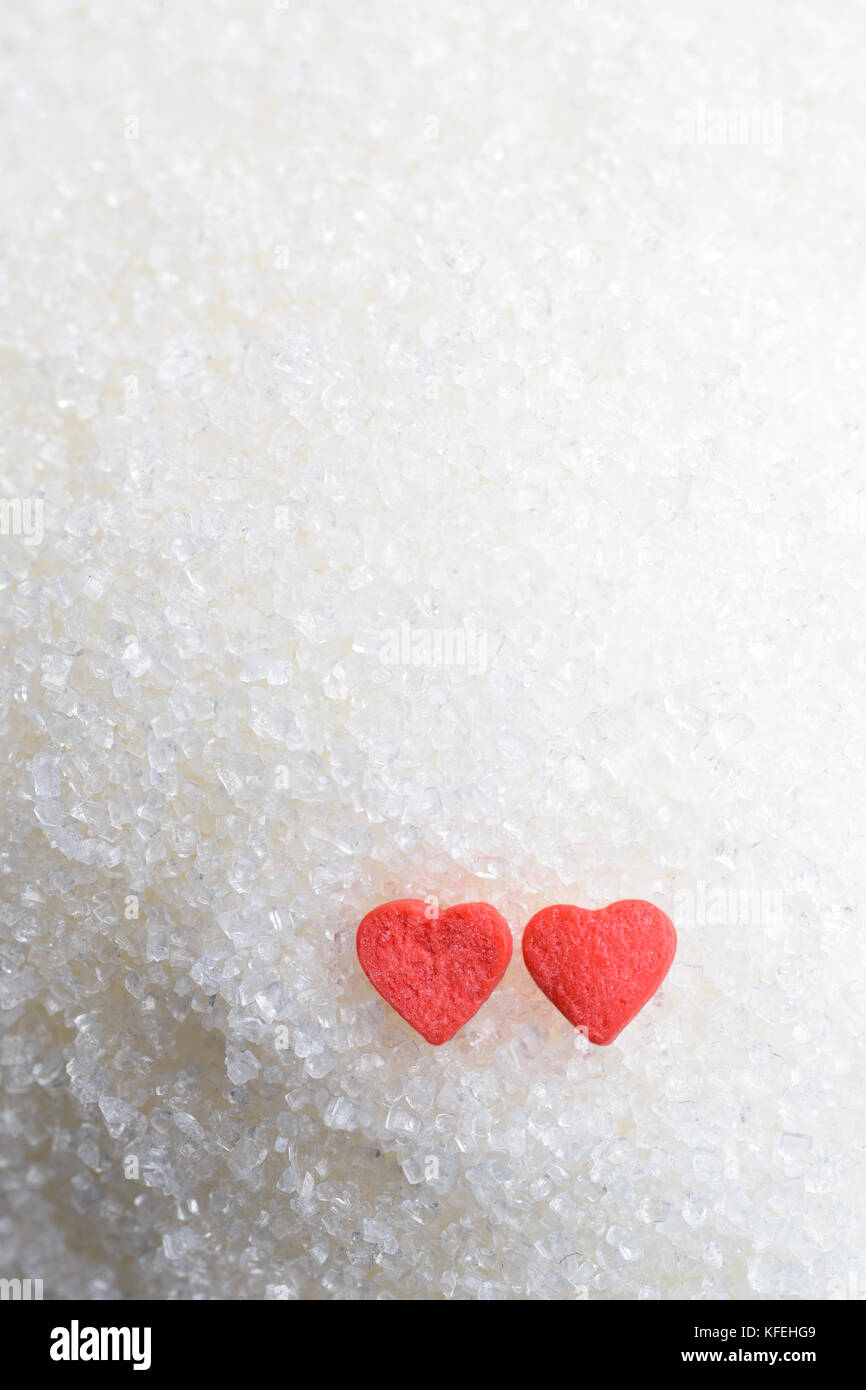 Heart shaped small candies on sugar as background Stock Photo - Alamy
