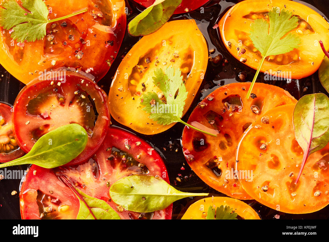 Sliced tomatoes with spices and oil on dark Stock Photo - Alamy