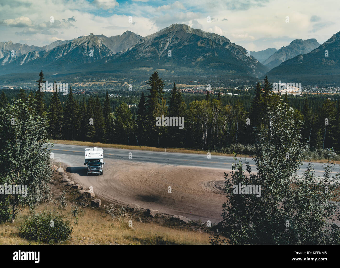 RV with empty street with mountain panorama in Banff National Pa Stock ...