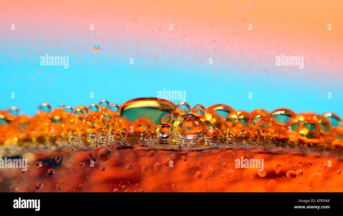 Oil drops on a water surface with color background Stock Photo - Alamy