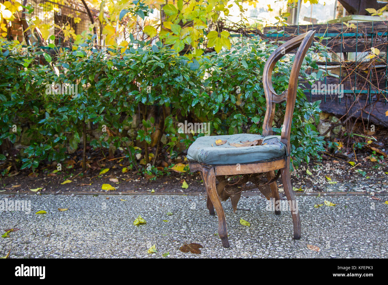 Old wooden chair with torn cloth and old rusty springs coming out from ...