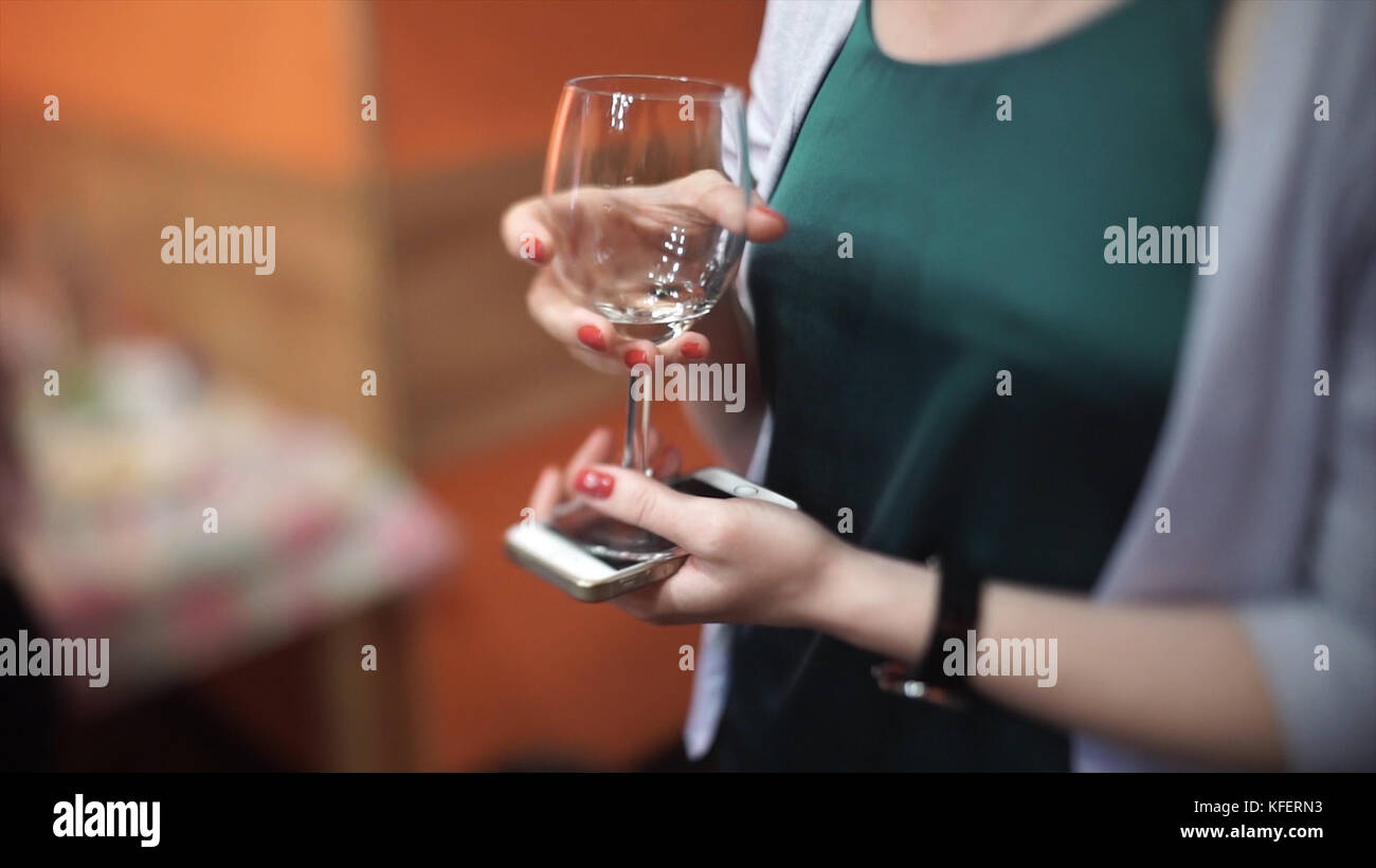 Woman standing with a glass and a telephone. Beautiful woman hand ...