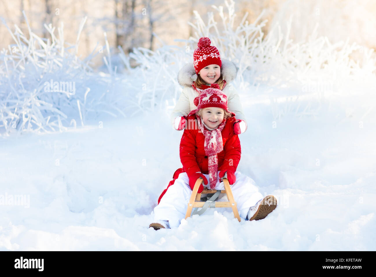 Little girl and boy enjoying sleigh ride. Child sledding. Toddler kid ...