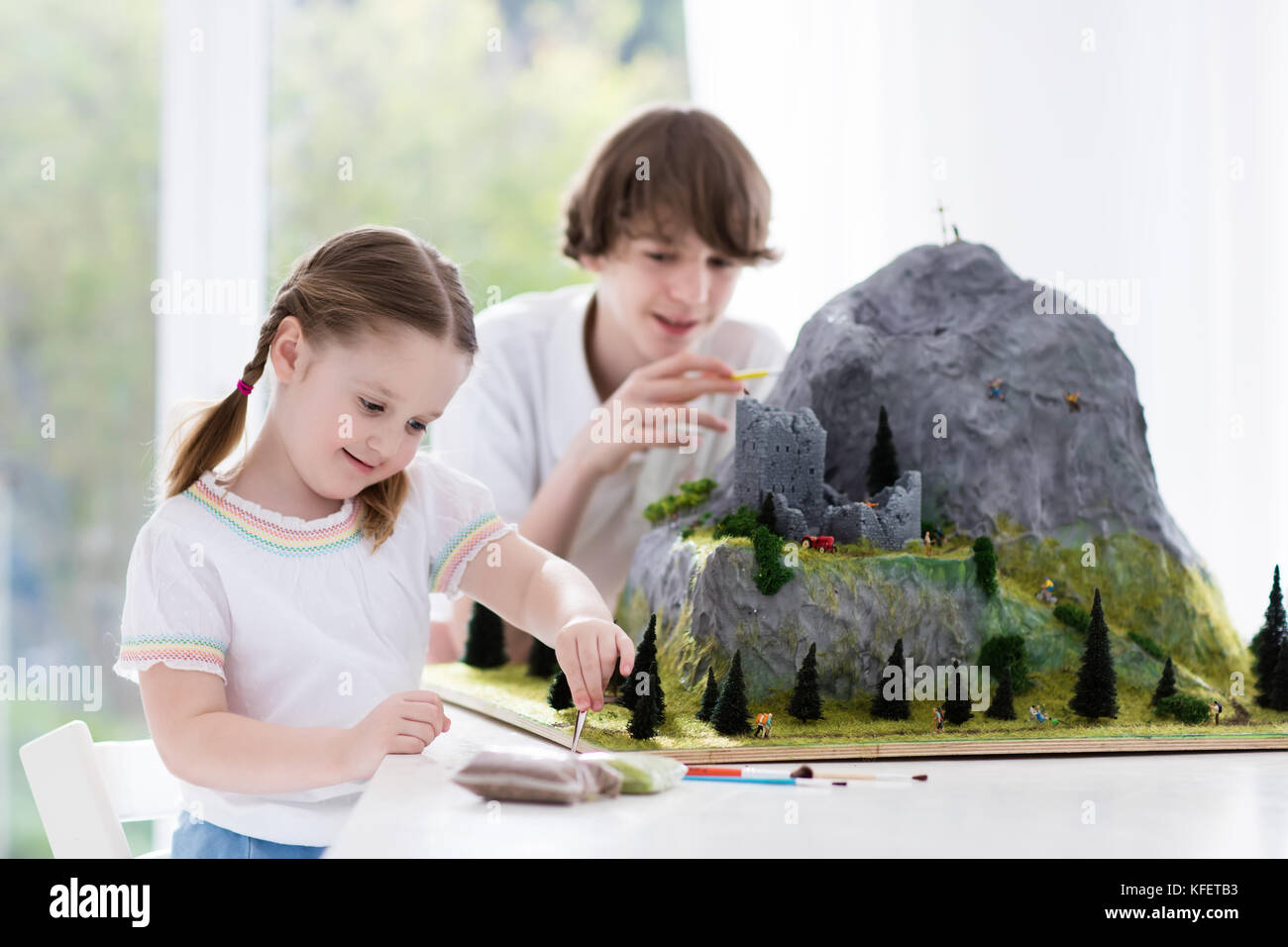 Children work on model building school project. Kids build miniature ...