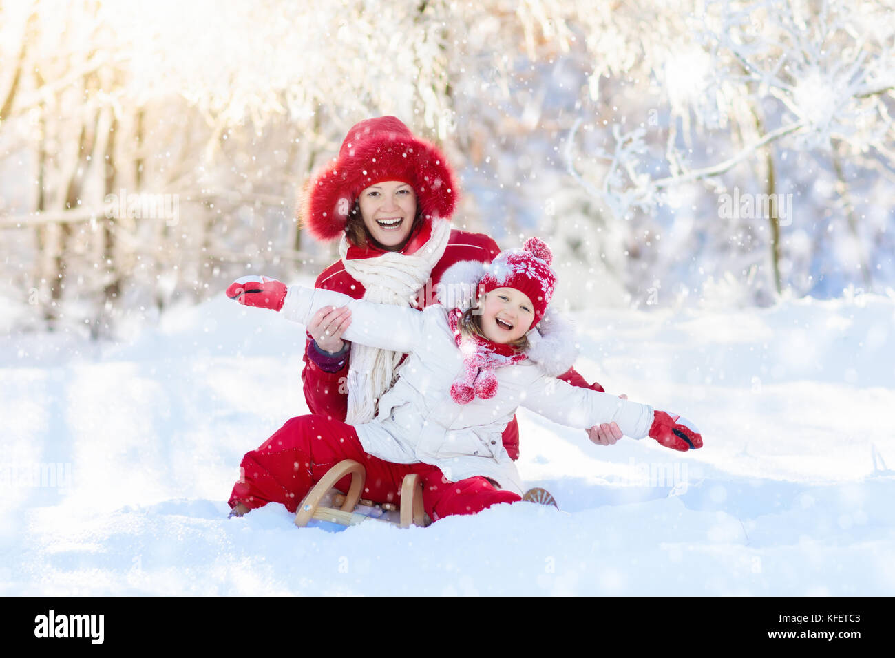 Mother and baby on sleigh ride. Child and mom sledding. Toddler kid ...