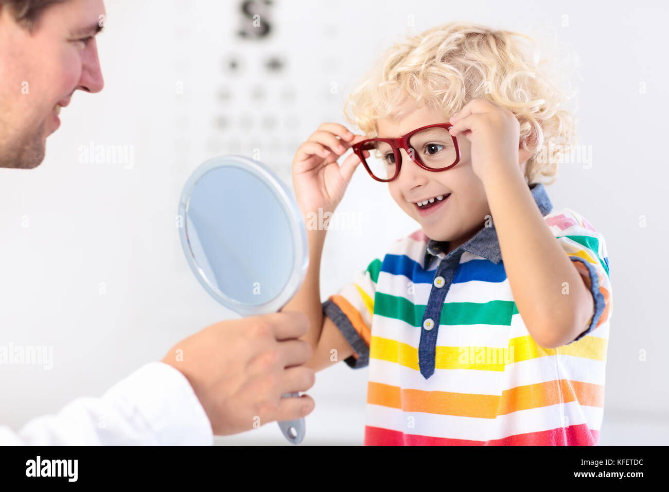 Child at eye sight test. Little kid selecting glasses at optician store ...