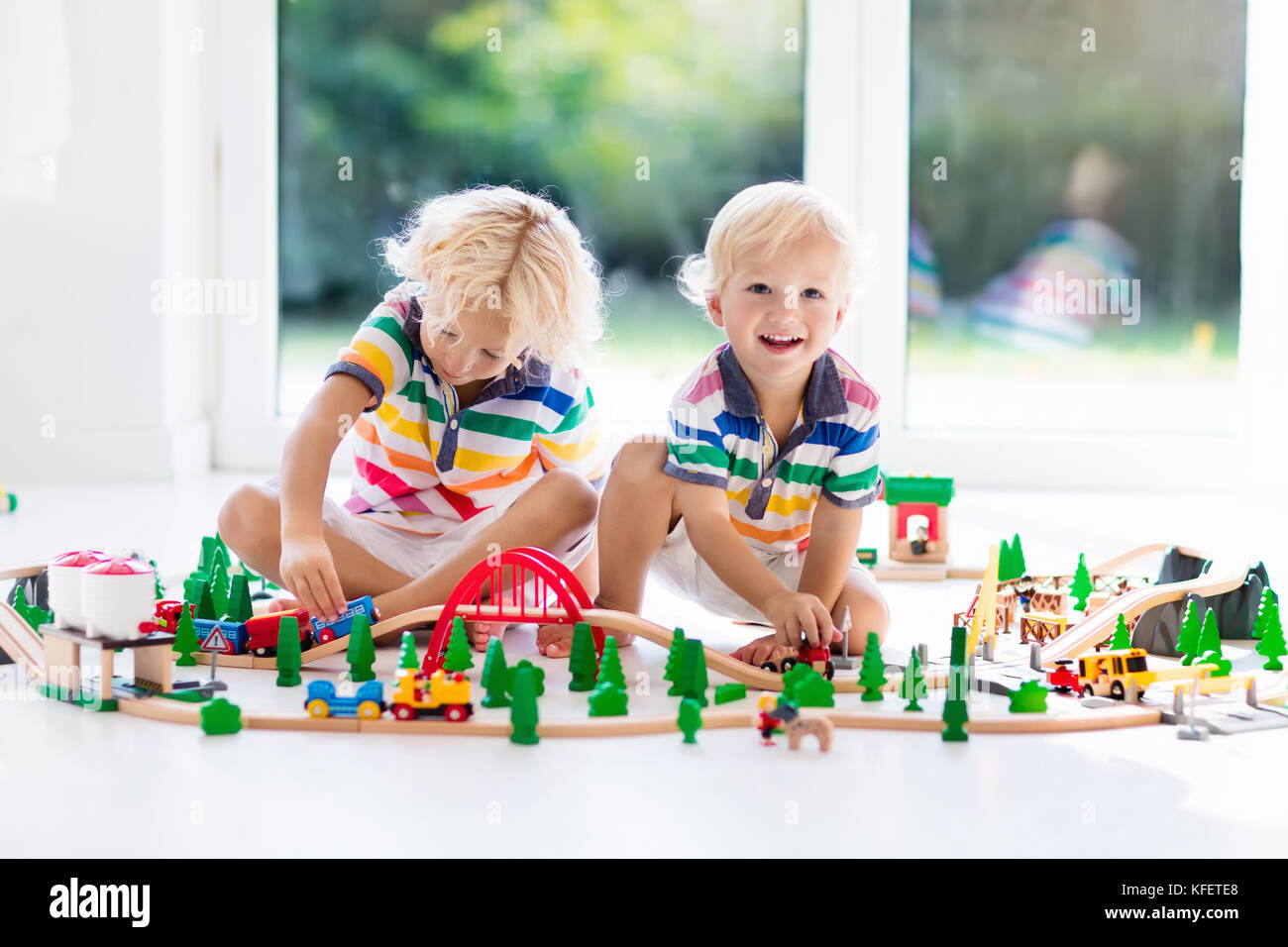 Kids play with toy train railway. Children playing with wooden trains ...