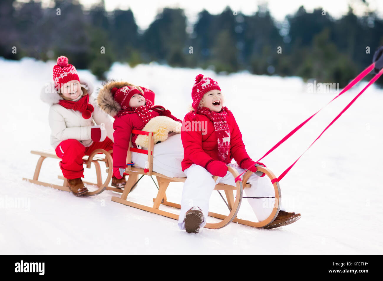 Little girl and boy enjoy a sleigh ride. Child sledding. Toddler kid ...