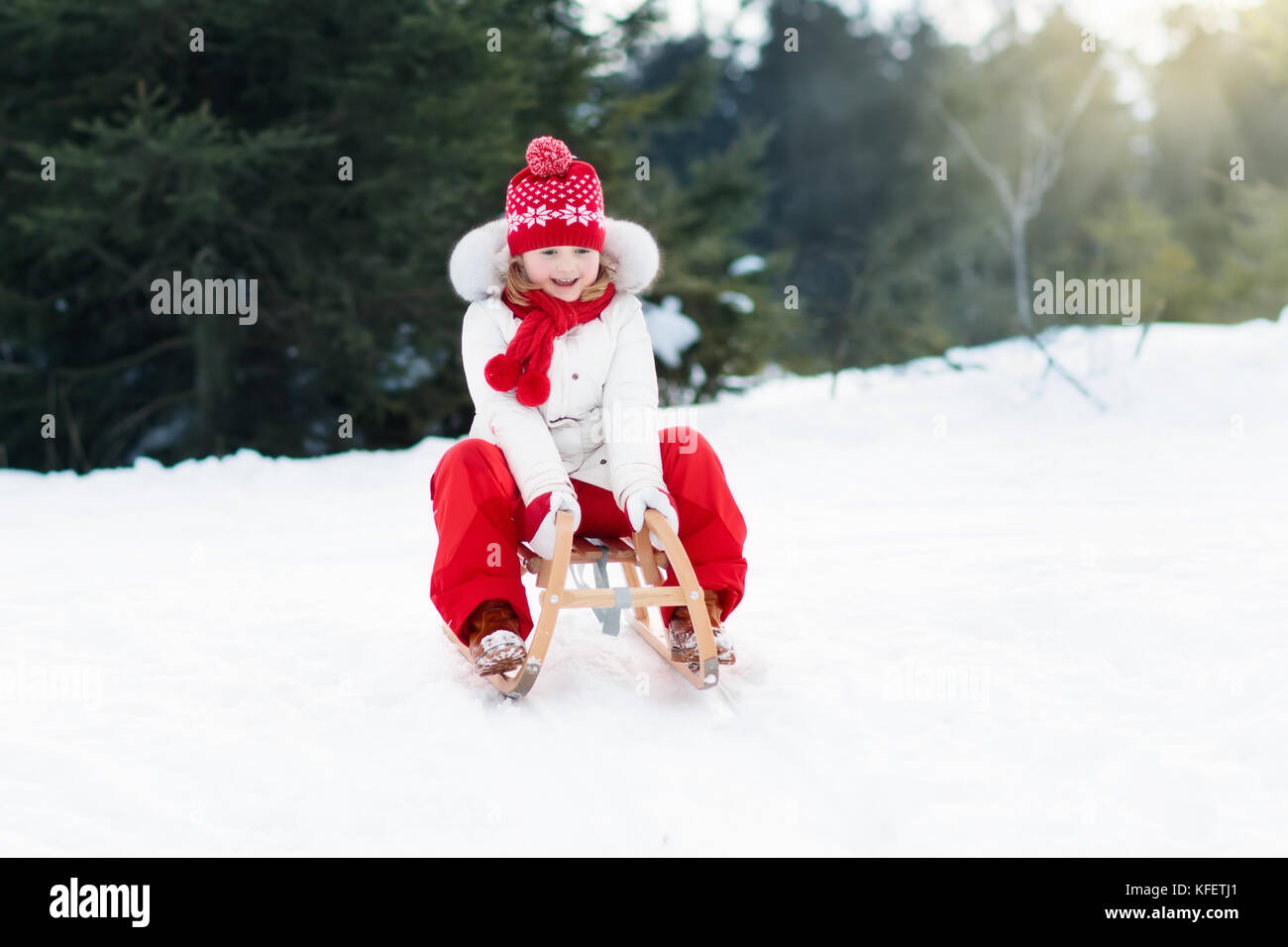 Little girl enjoying a sleigh ride. Child sledding. Toddler kid riding ...