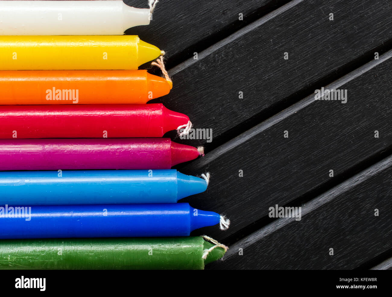 Many colorful candles in a single row and line, black background ...