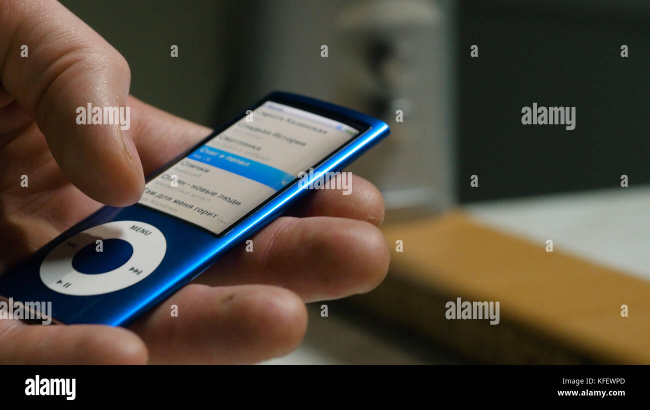 Music player in male hand, on home interior background. Toggles the ...