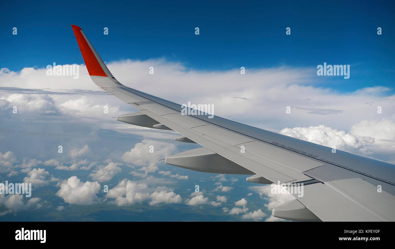 Wing of airplane on sky and cloud on moving, view from airplane cabine ...