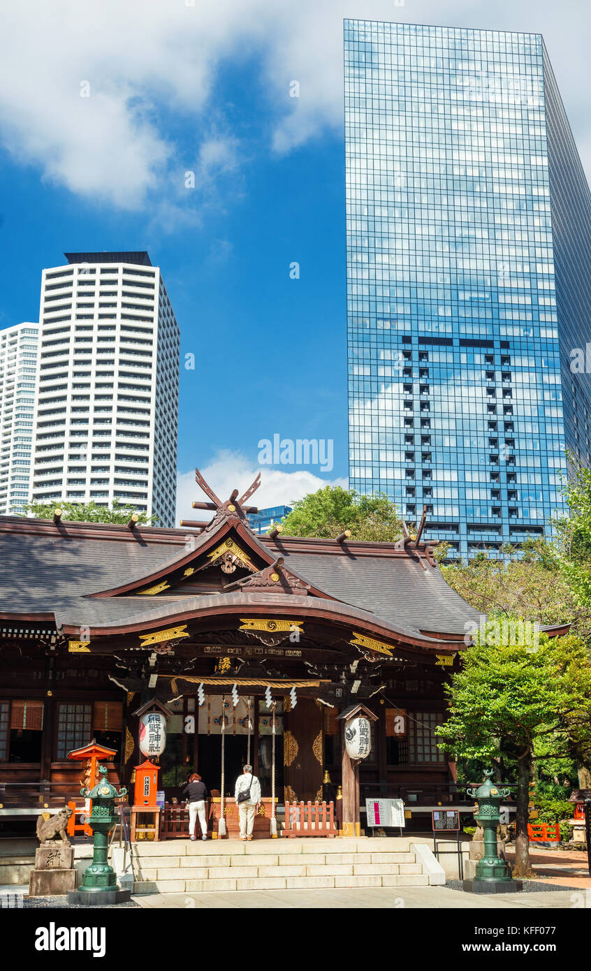 Tradition and Modernity in Japan. People pray in an old temple below ...