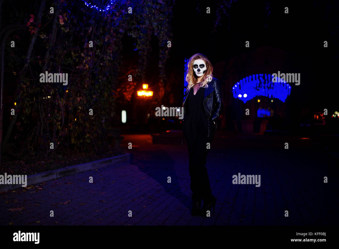 Halloween skull make up girl wear in black at night street of city ...