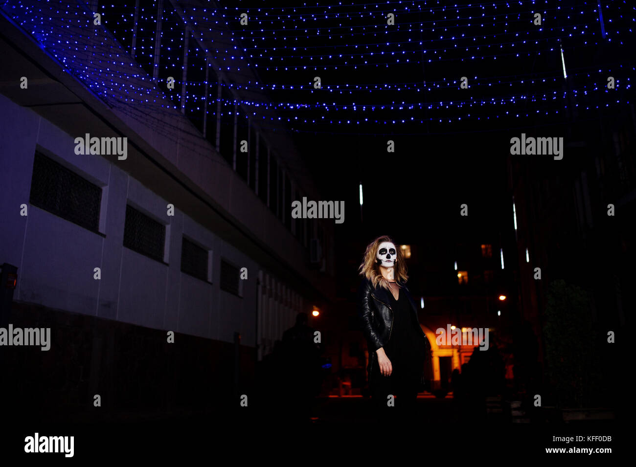 Halloween skull make up girl wear in black at night street of city ...