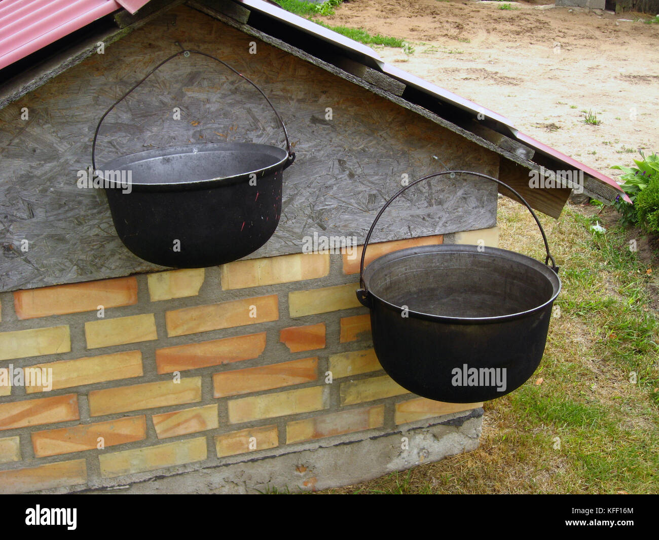 Big cooking pots, hanging on the well Stock Photo - Alamy