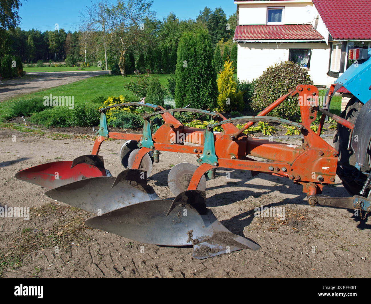 Tractor powered three furrow plow in country yard Stock Photo - Alamy