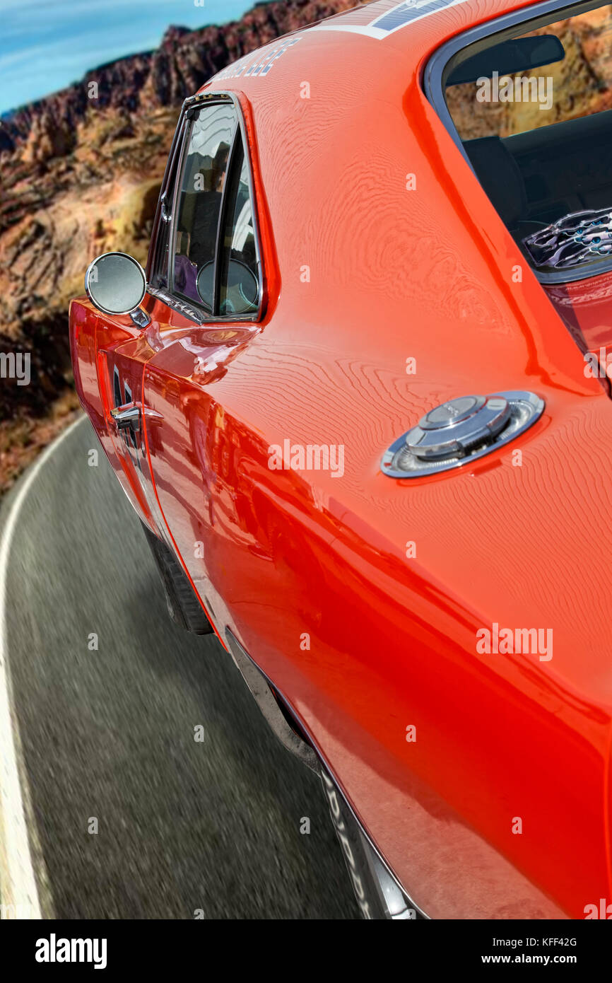 Orange American muscle car speeding down memory lane Stock Photo - Alamy