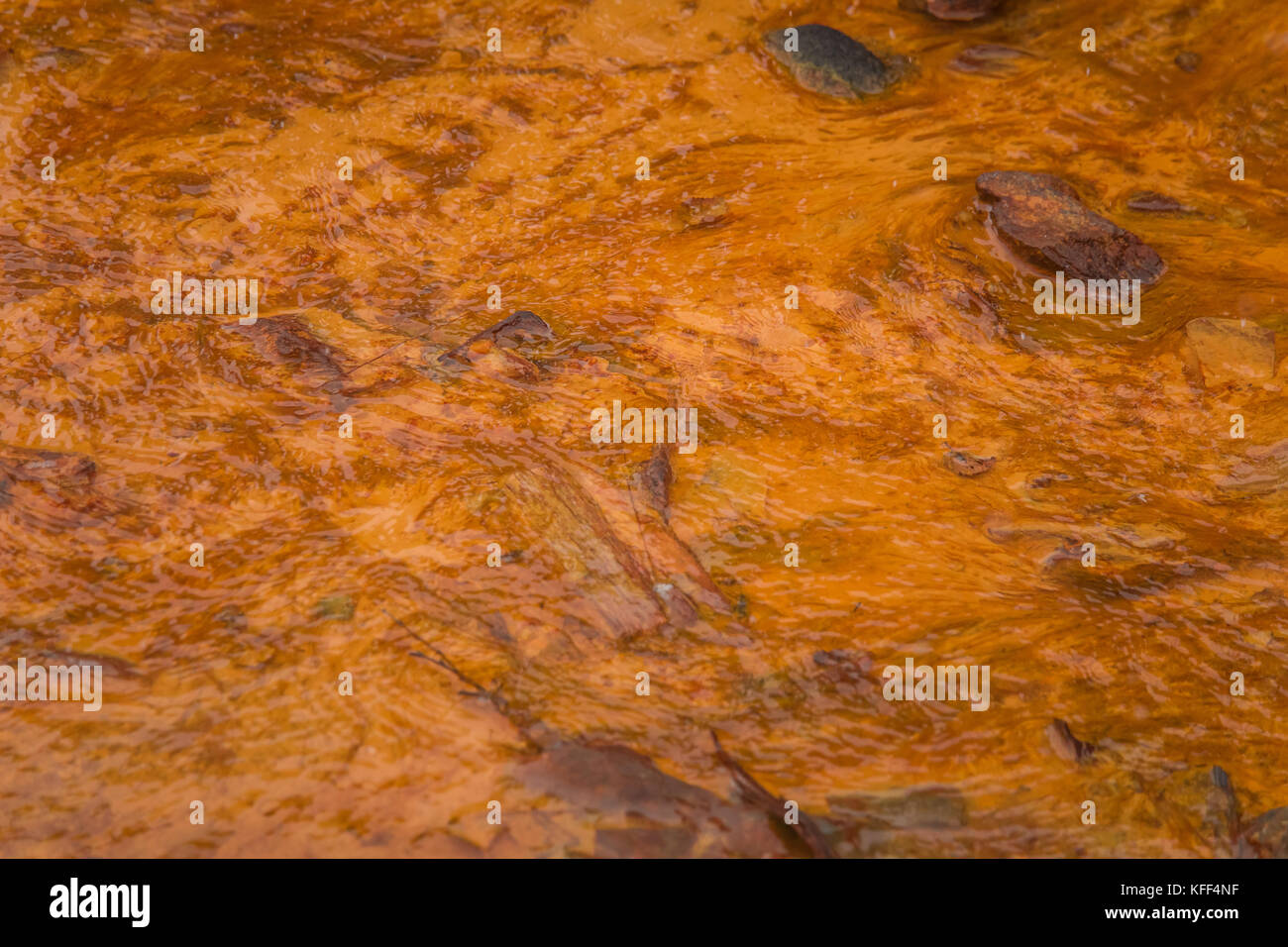 An orange rusty water at the old copper mine in Norway in winter ...
