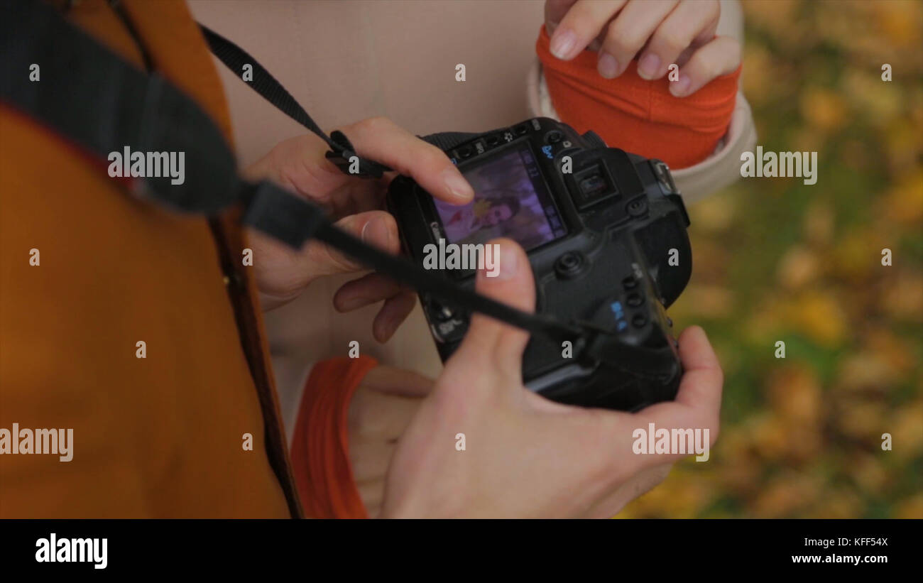 Couple looking at pictures through camera screen. Tourists in Guell ...