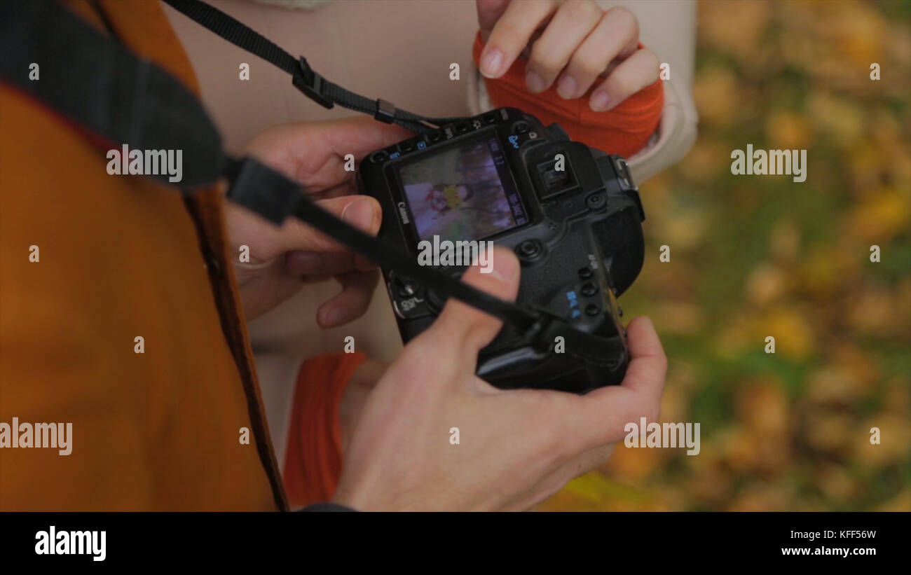 Couple looking at pictures through camera screen. Tourists in Guell ...