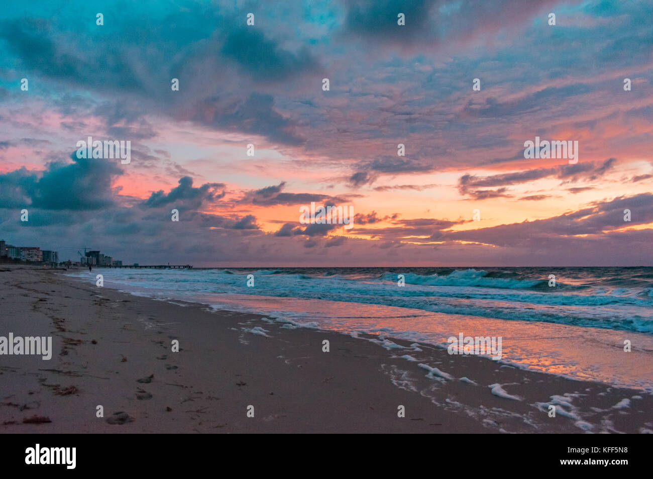 blue and pink colored sky reflecting on the ocean as the sun rises on ...