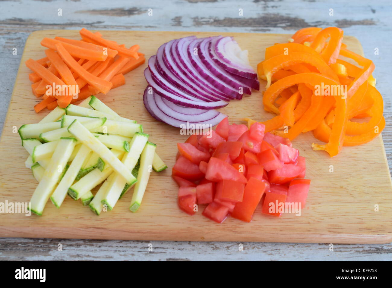 Cut and diced vegetables on a wooden cutting board. Onion, tomato ...