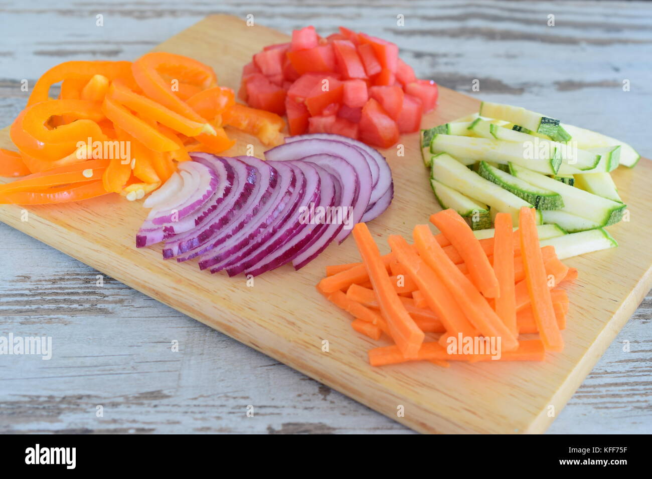 Cut and diced vegetables on a wooden cutting board. Onion, tomato ...