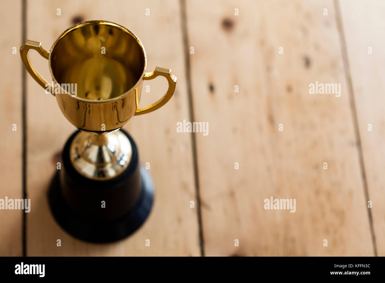 Gold winners trophy award on a wooden background Stock Photo - Alamy