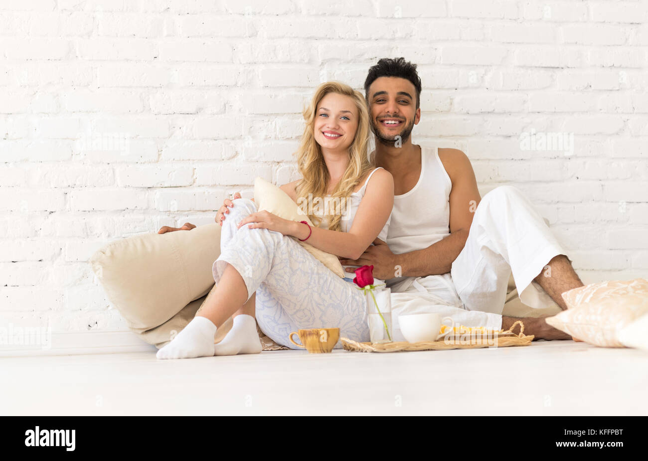 Young Couple Sit On Pillows Floor, Happy Hispanic Man And Woman ...