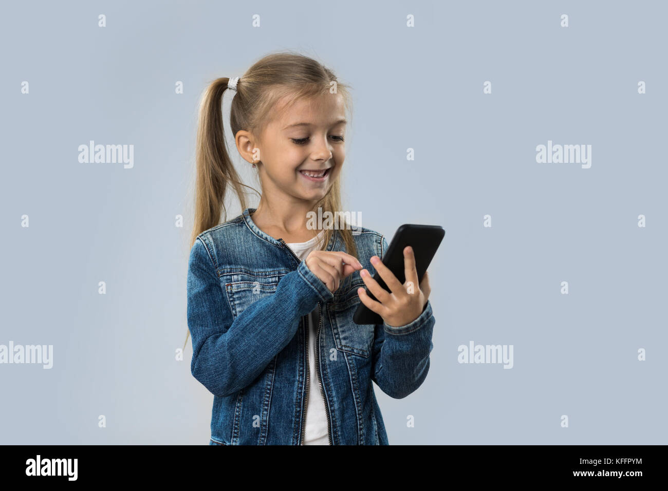 Beautiful Little Girl Using Cell Smart Phone Happy Smiling Wear Jeans ...