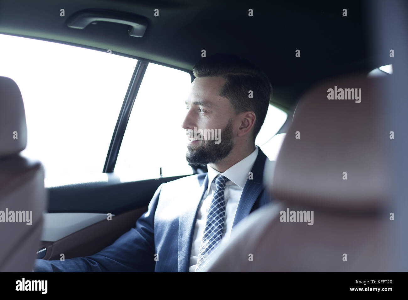 Smiling successful man sitting in the back seat of a car Stock Photo ...