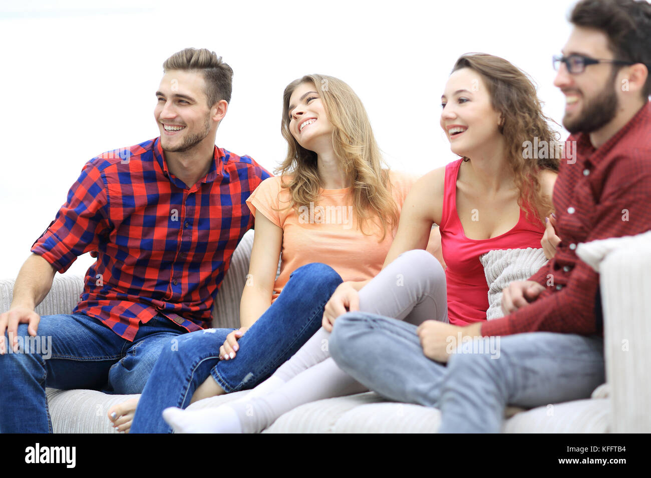 group of cheerful friends sitting on the couch in the living room Stock ...