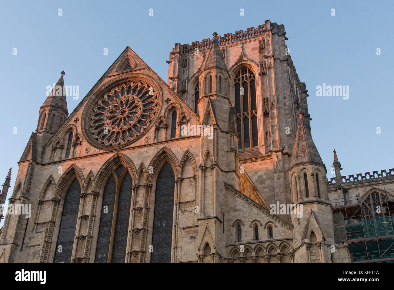 Golden evening sunlight illuminates circular Rose Window and high ...
