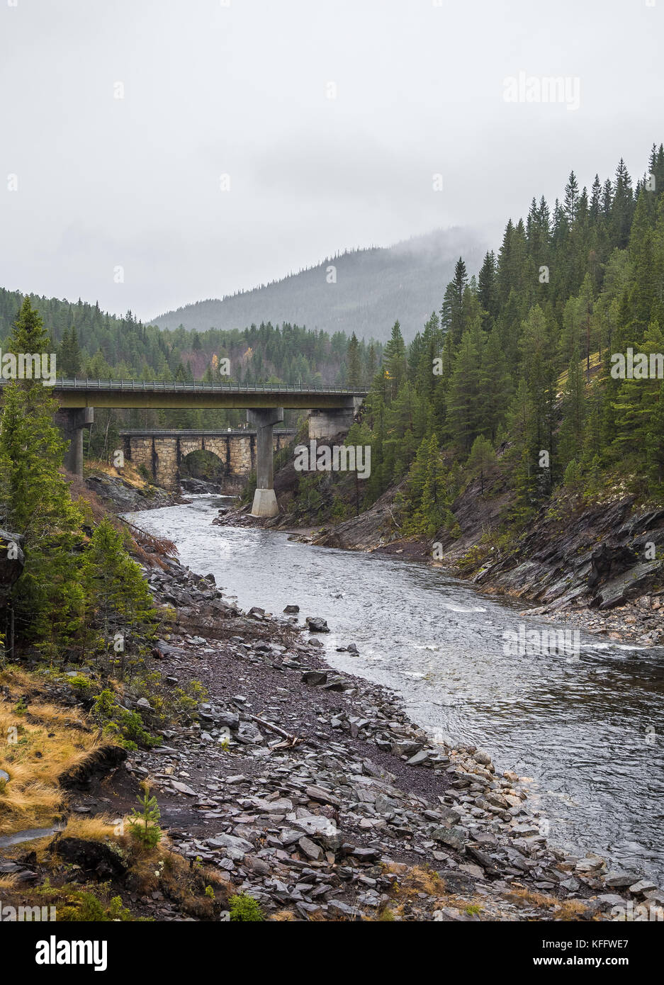 A beautiful historic stone bridge crossing the river in central Norway ...