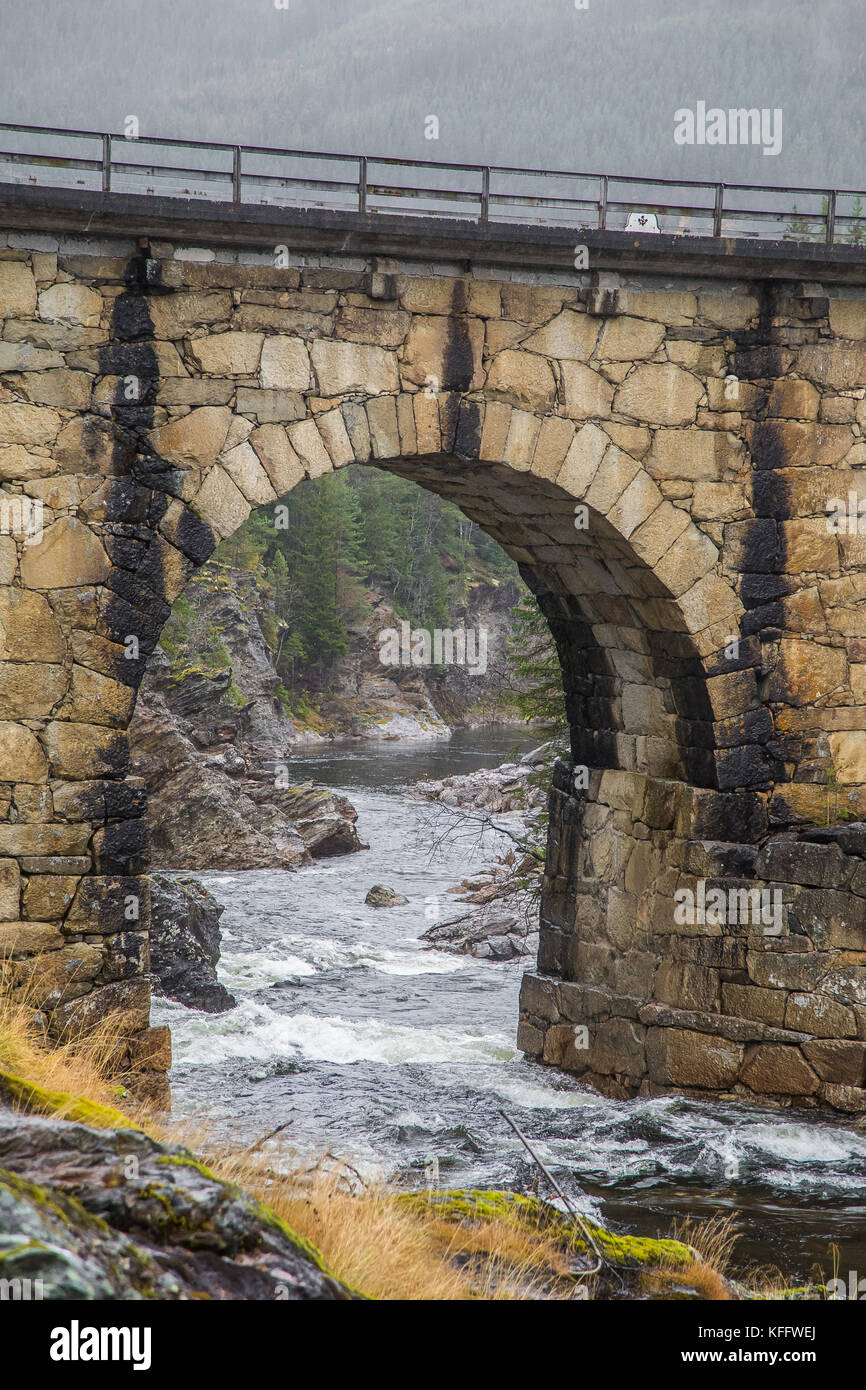 A beautiful historic stone bridge crossing the river in central Norway ...
