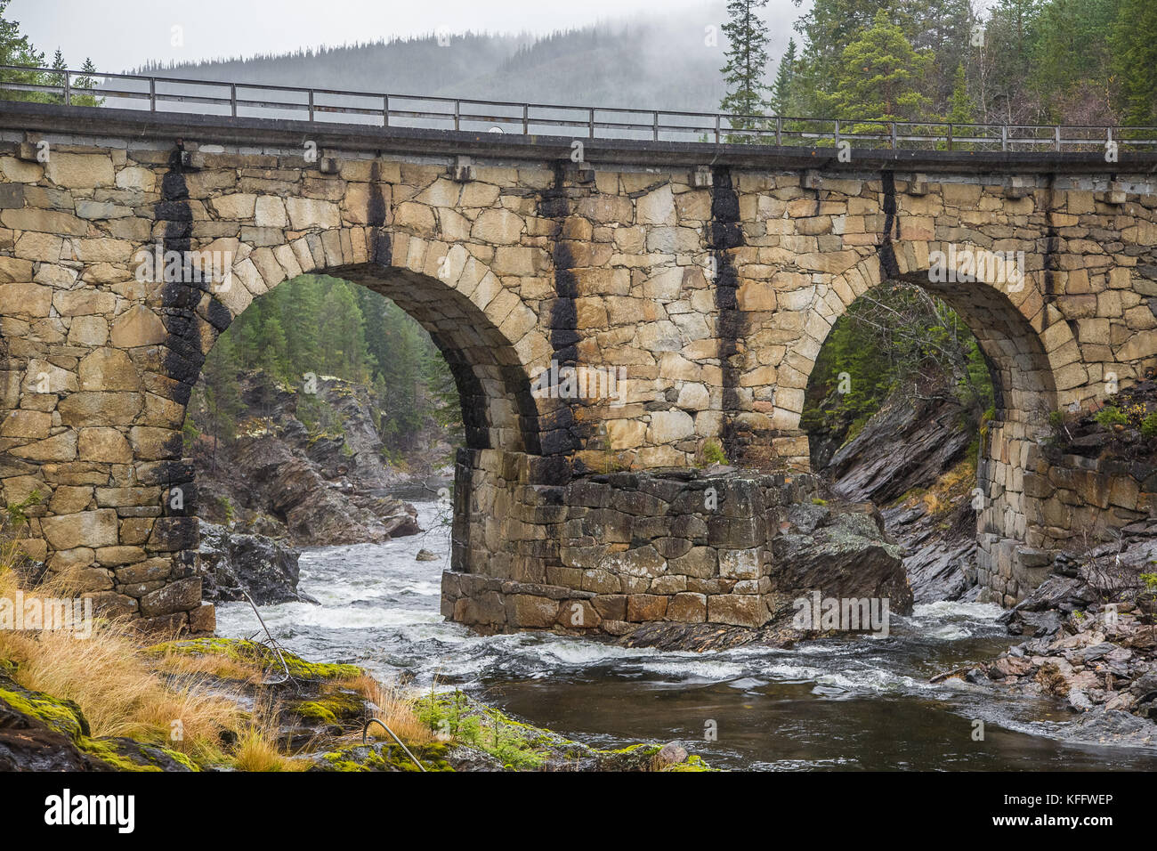 A beautiful historic stone bridge crossing the river in central Norway ...