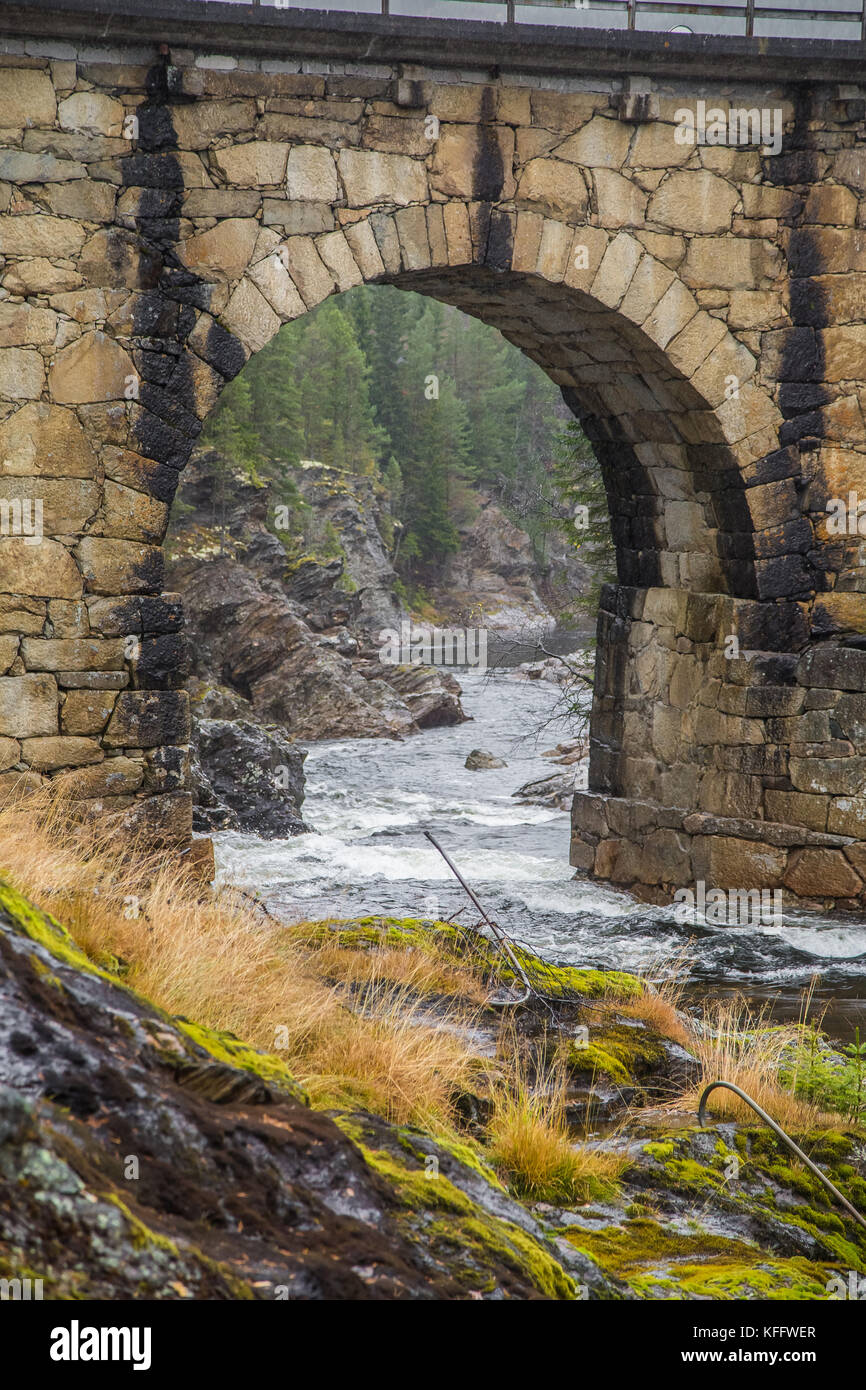 A beautiful historic stone bridge crossing the river in central Norway ...