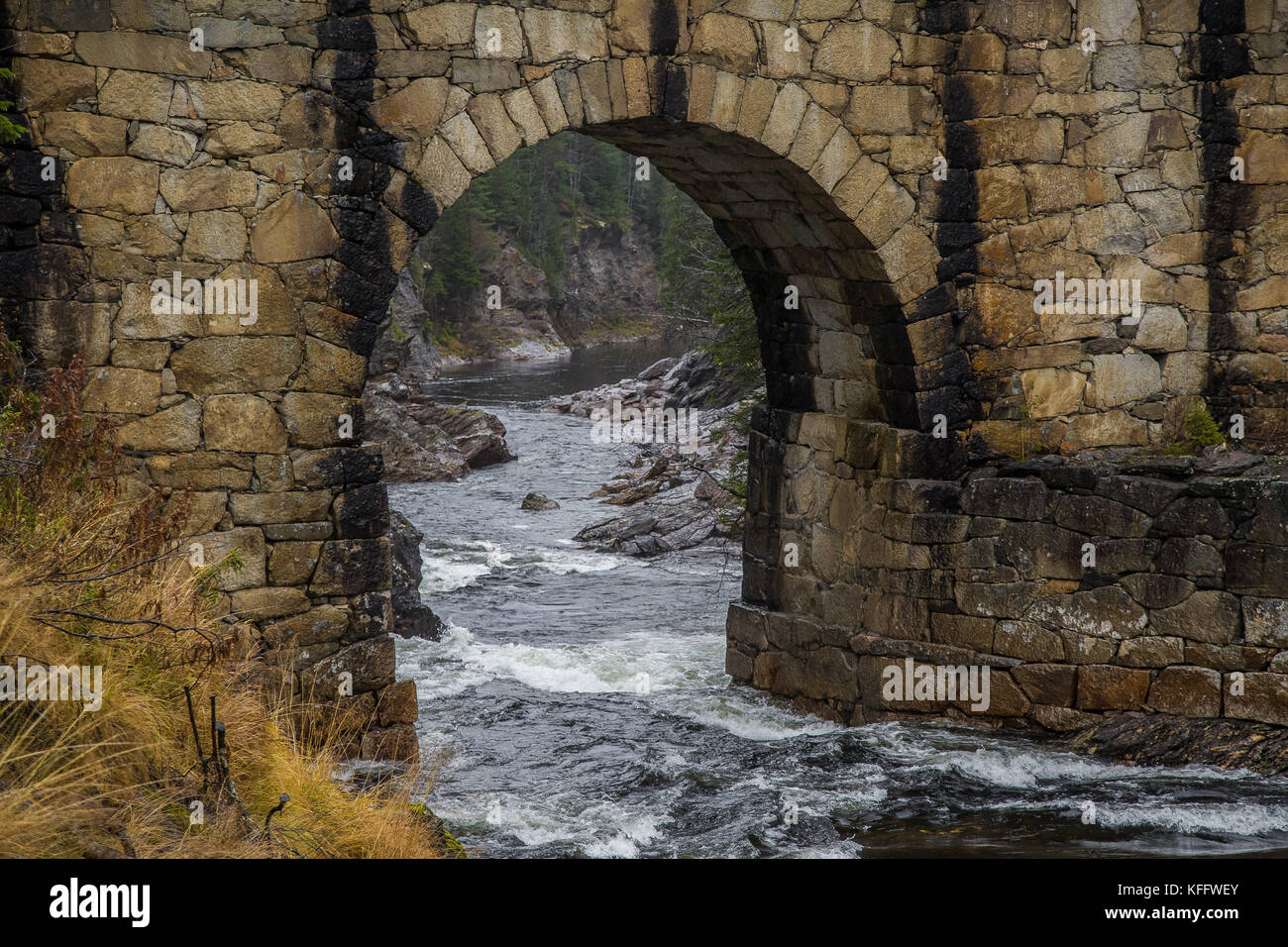 A beautiful historic stone bridge crossing the river in central Norway ...