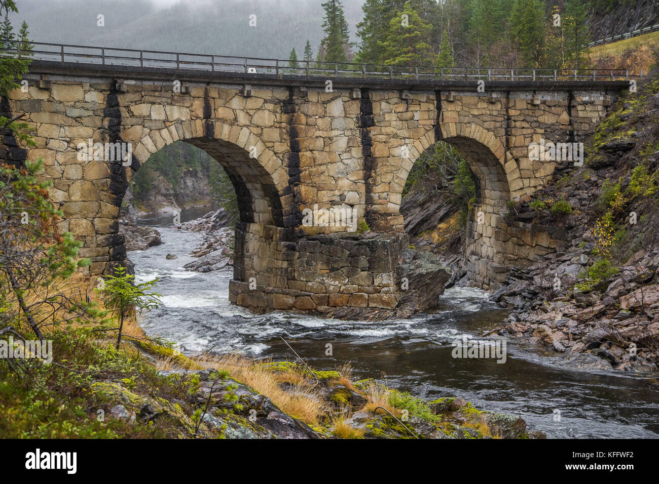 A beautiful historic stone bridge crossing the river in central Norway ...