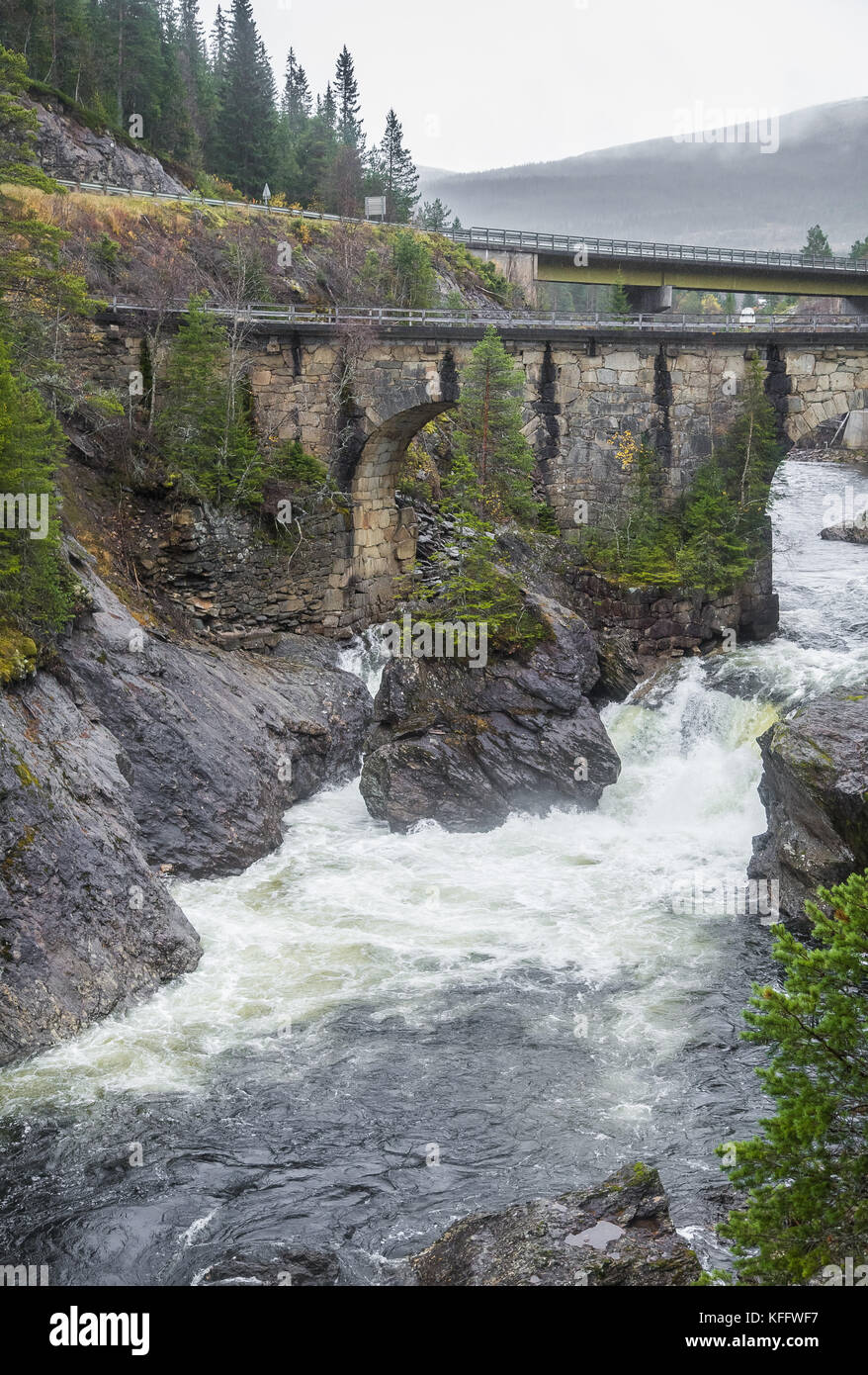 A beautiful historic stone bridge crossing the river in central Norway ...