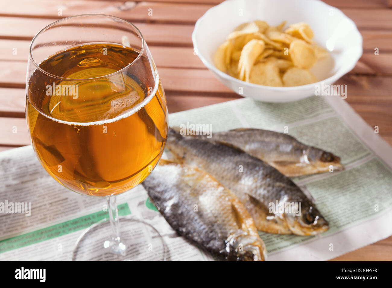 Lager beer and dry fish, garlic and chips on wooden table Stock Photo ...
