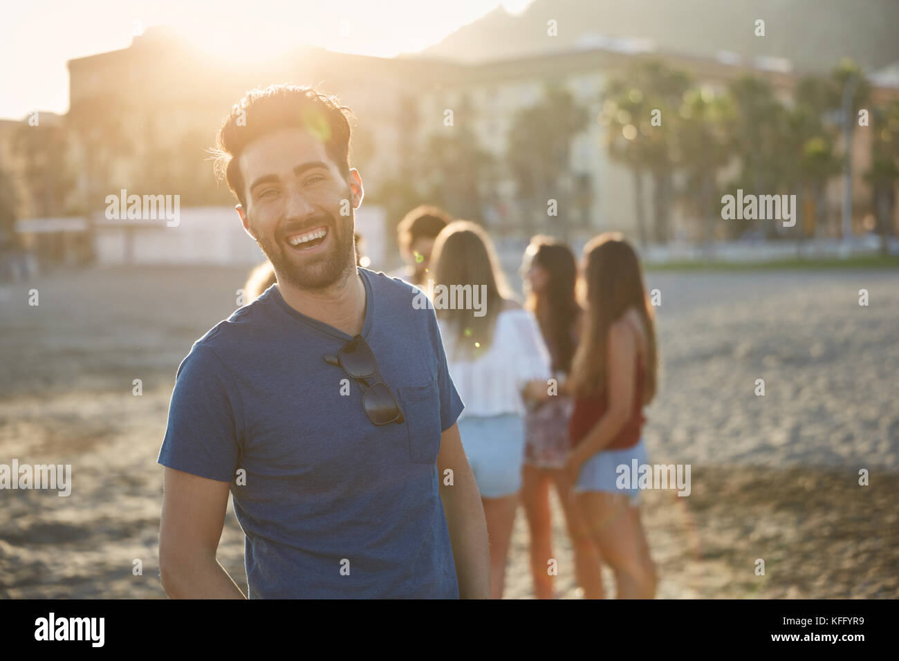 Portrait of handsome man laughing with friends behind him Stock Photo ...
