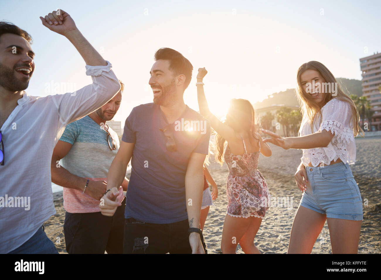Portrait of young women dancing with their boyfriends on beach Stock ...