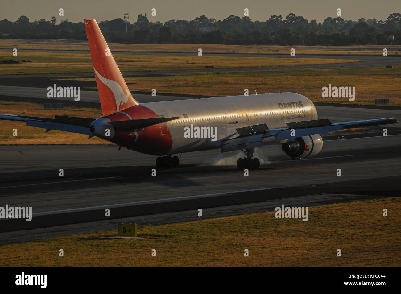 A QANTAS commercial Boeing 757 airliner landing at airport, with smoke ...