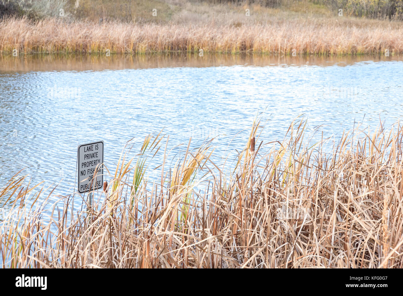 A sign warning that a lake is private in front of a small pond at the ...