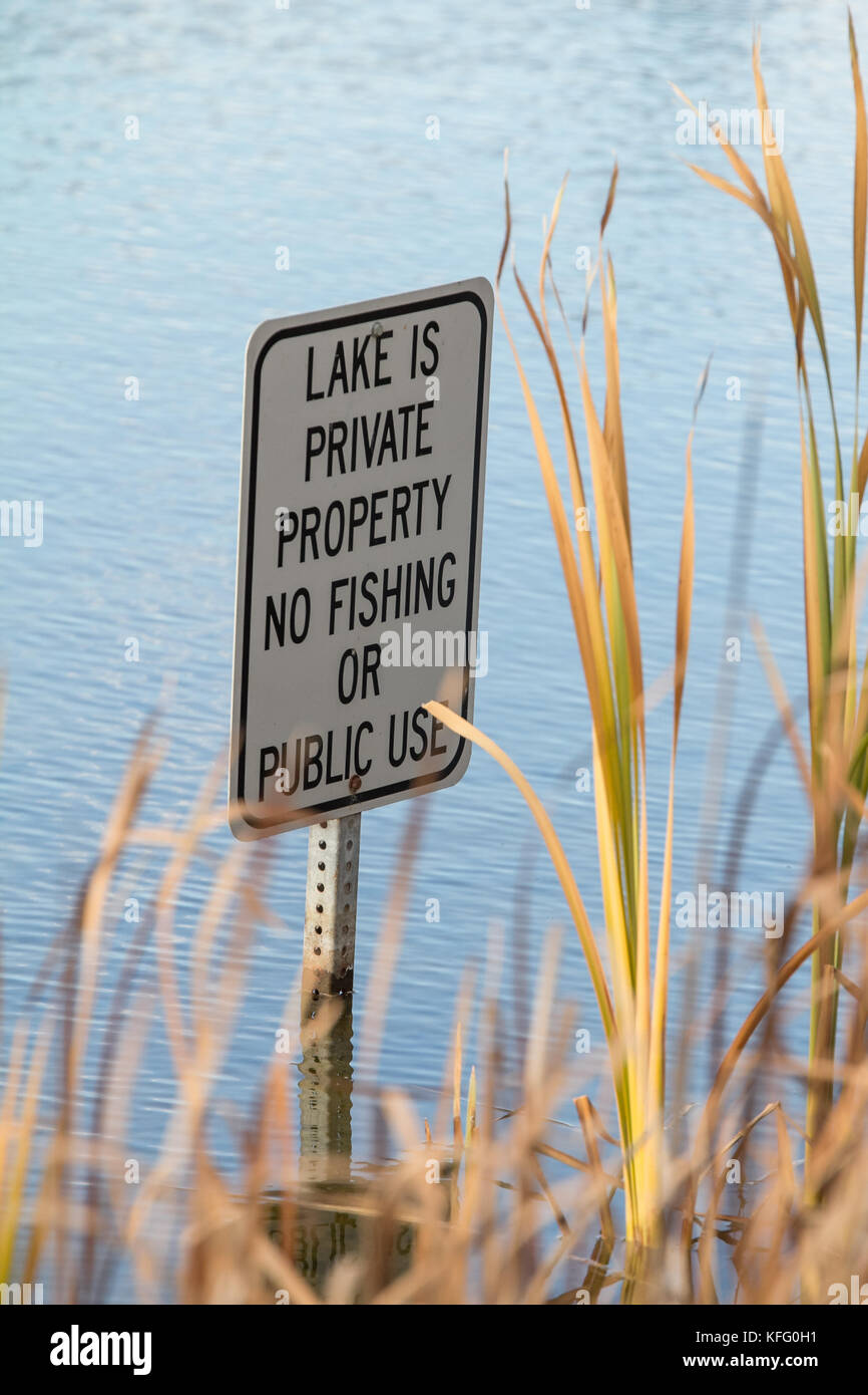 A sign warning that a lake is private in front of a small pond at the ...